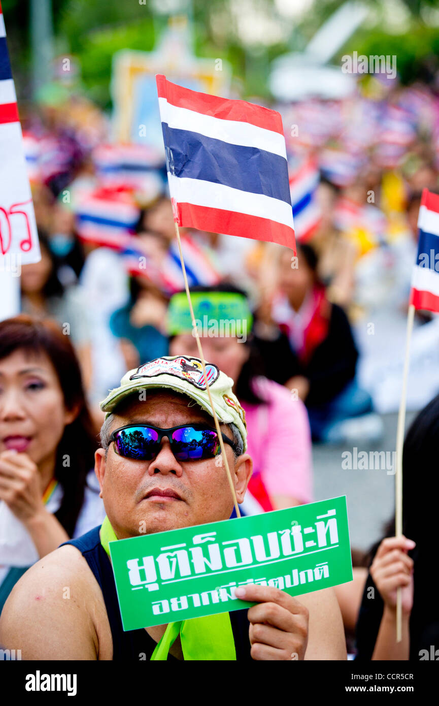 A supporter of Thai Prime Minister Abhisit Vejjajiva holds Thai flag ...