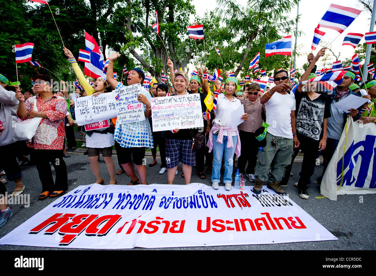 Supporters of Thai Prime Minister Abhisit Vejjajiva wave flags behind a ...