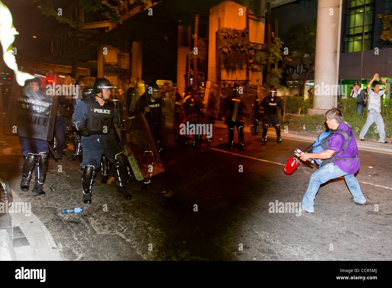 A pro-government supporter slings a fire extinguisher at Thai riot ...