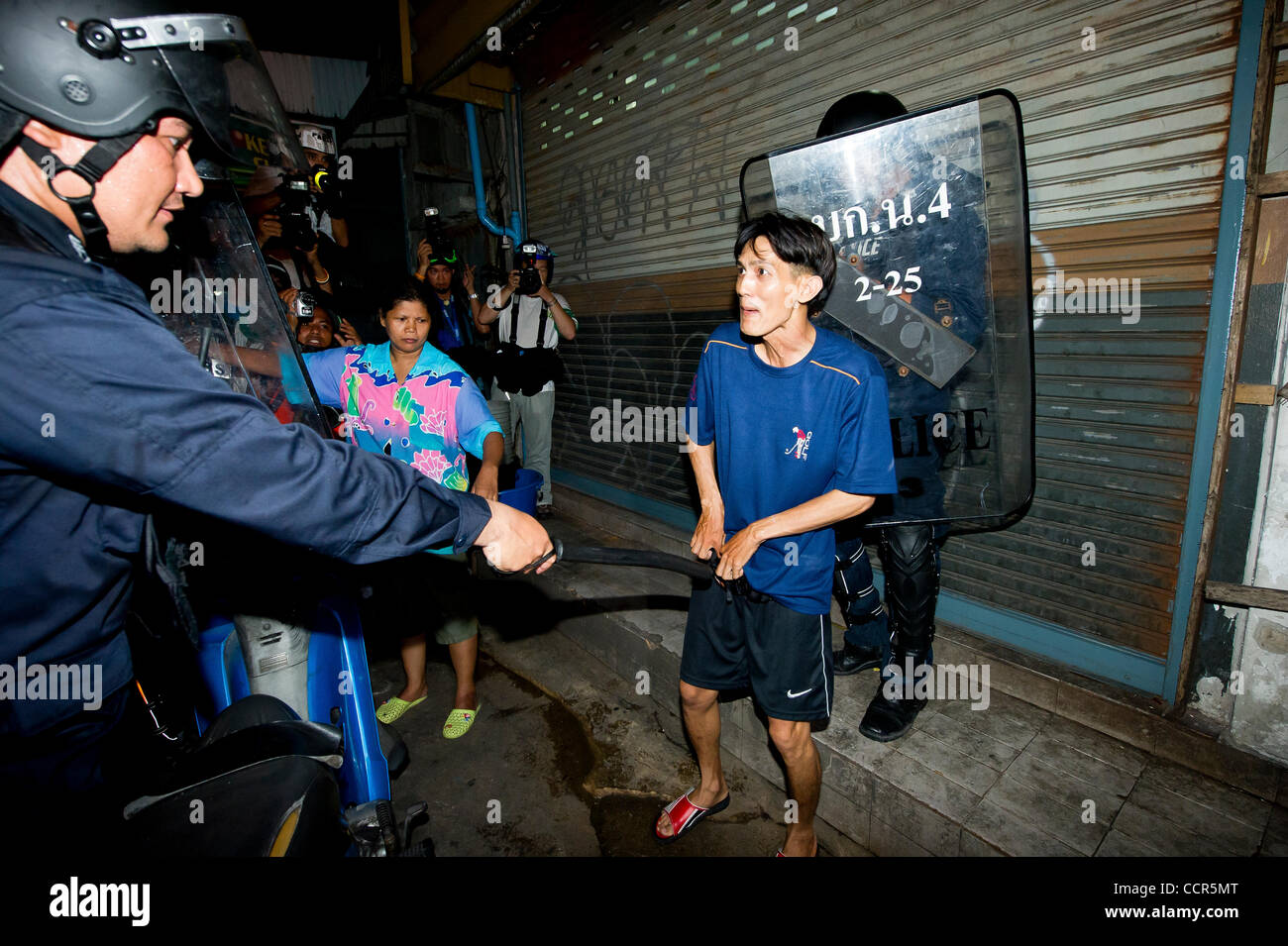 Thai riot police search a man on Silom road after a clash between pro ...