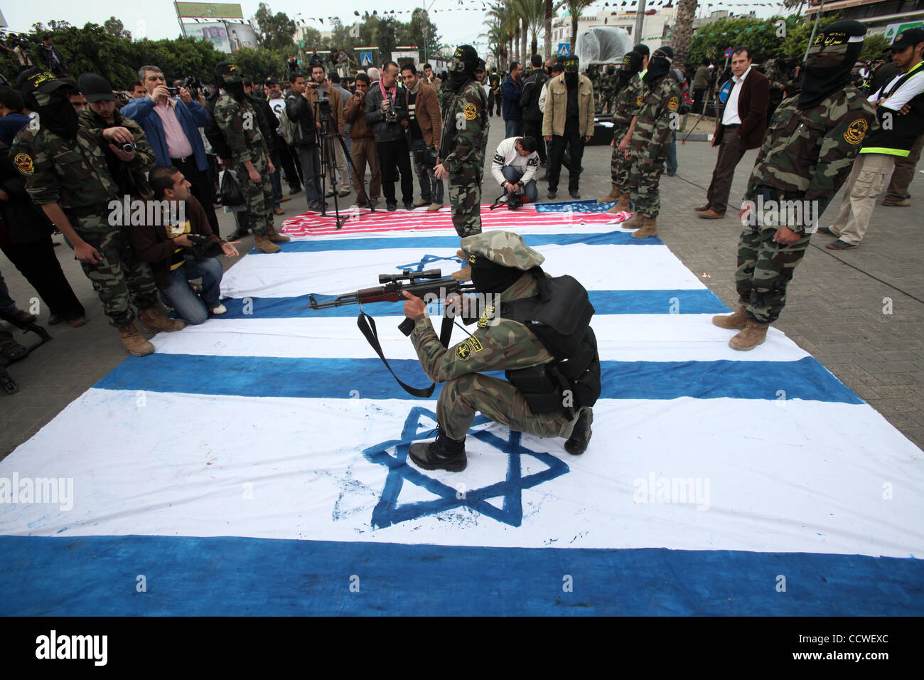 Palestinian Islamic Jihad militants takes position on an Israeli flag ...