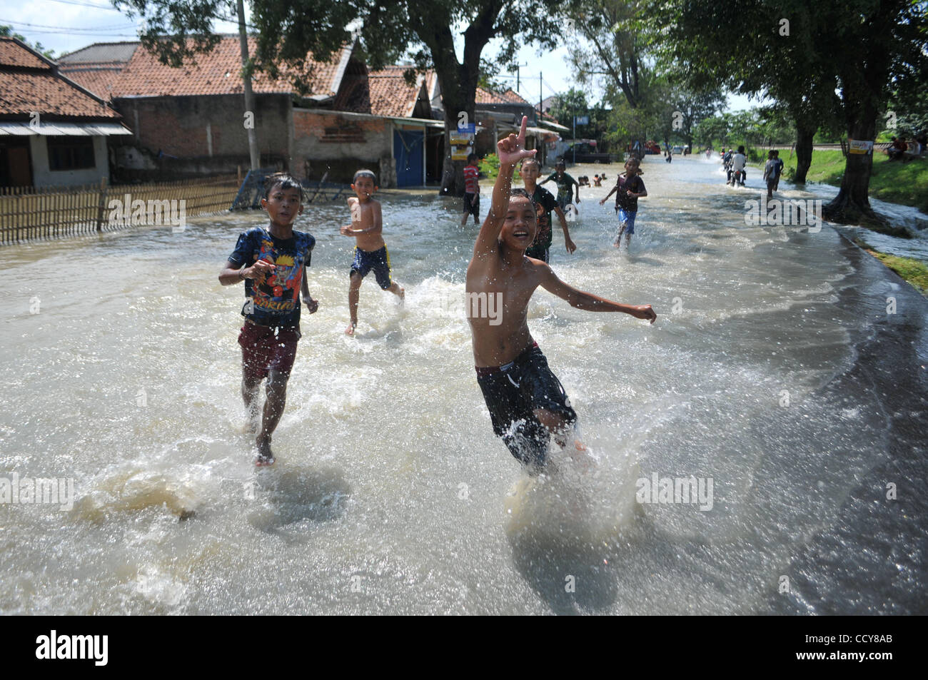 Residents walk through flood water In Karawang, West Java province ...