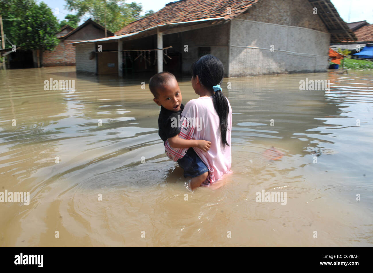 Residents walk through flood water In Karawang, West Java province ...