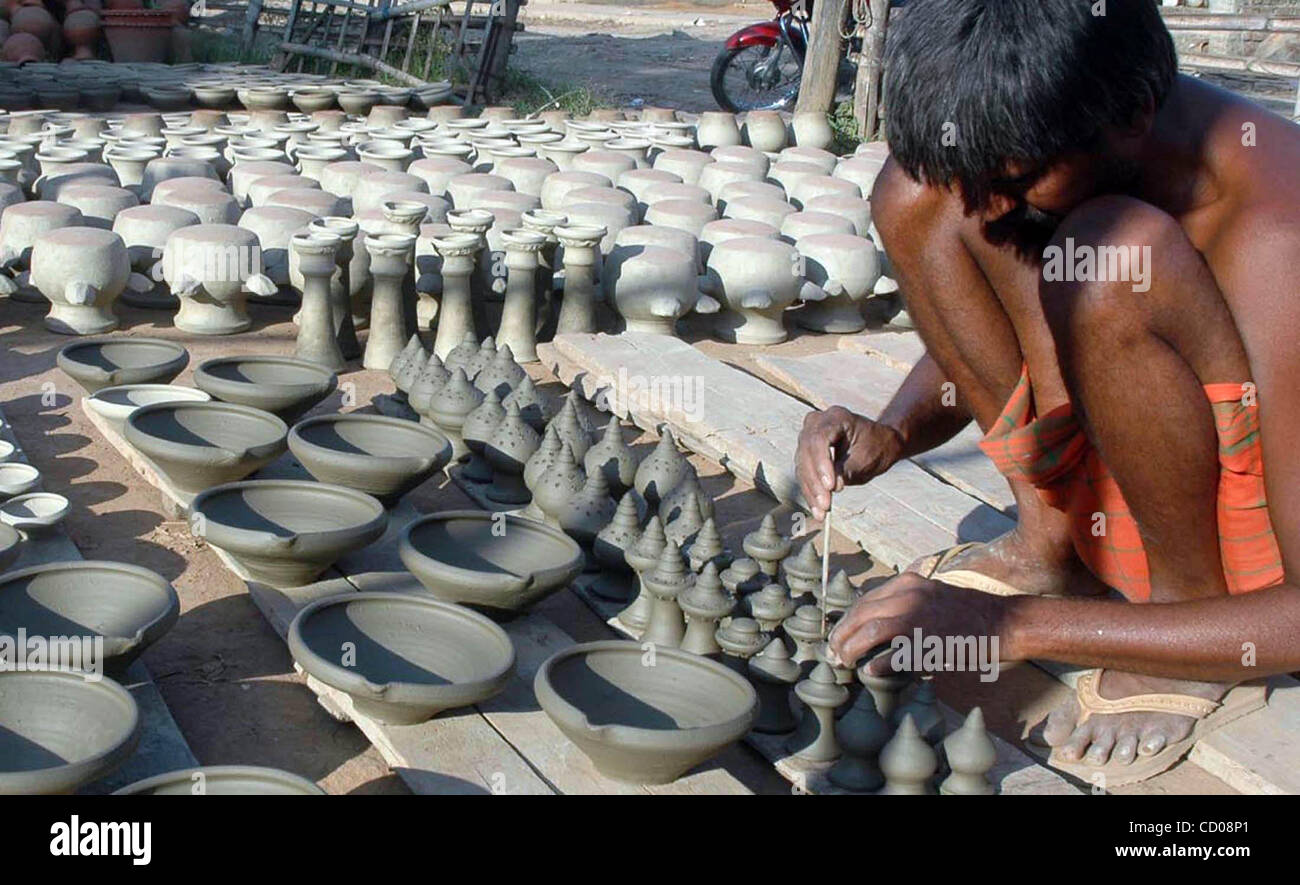 A pot maker seen busy in making Earthen lamps (saki) and Earthen pots ...