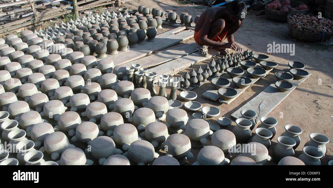 A pot maker seen busy in making Earthen lamps (saki) and Earthen pots ...