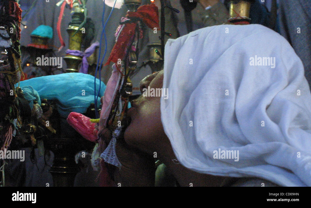 A kashmiri women Devotees kissing on the holy chain of shrine of ...