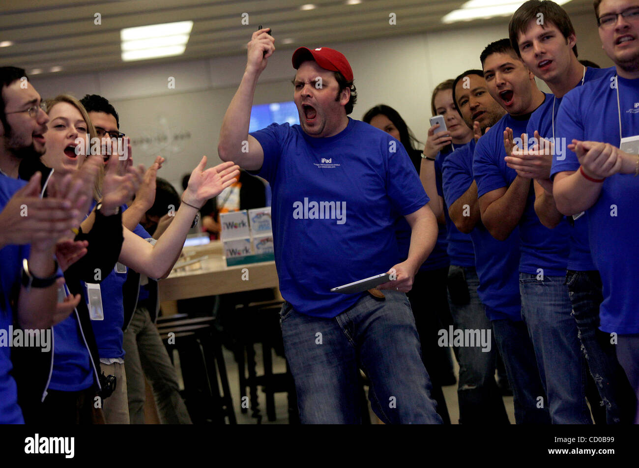 METRO - Holding an iPad, Store Leader Brian Regnier cheers with his ...