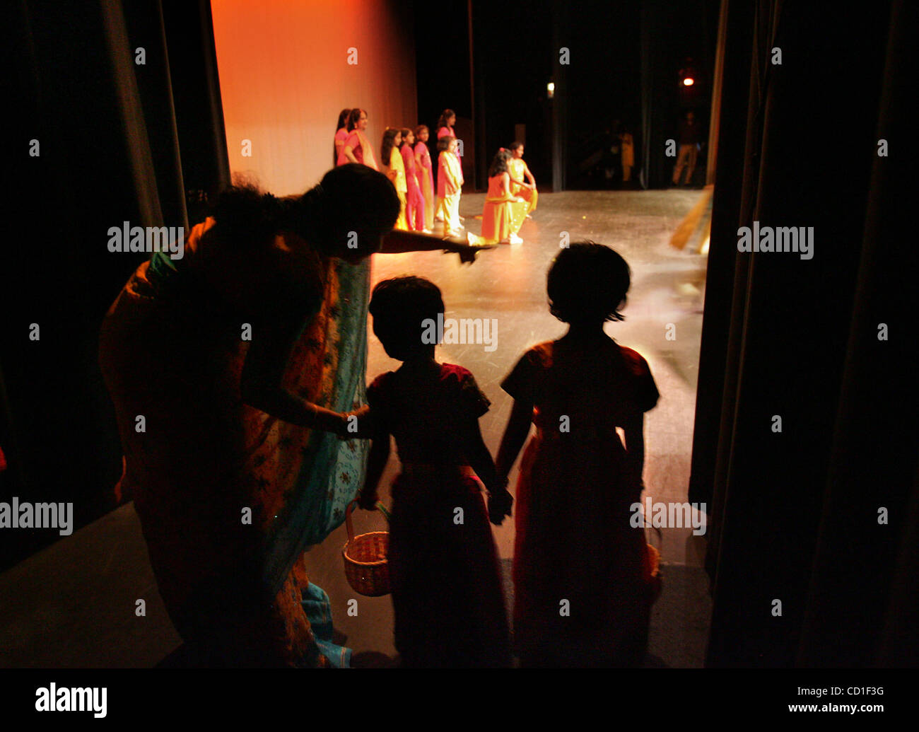A mother gives stage instructions before the kids go on stage to ...