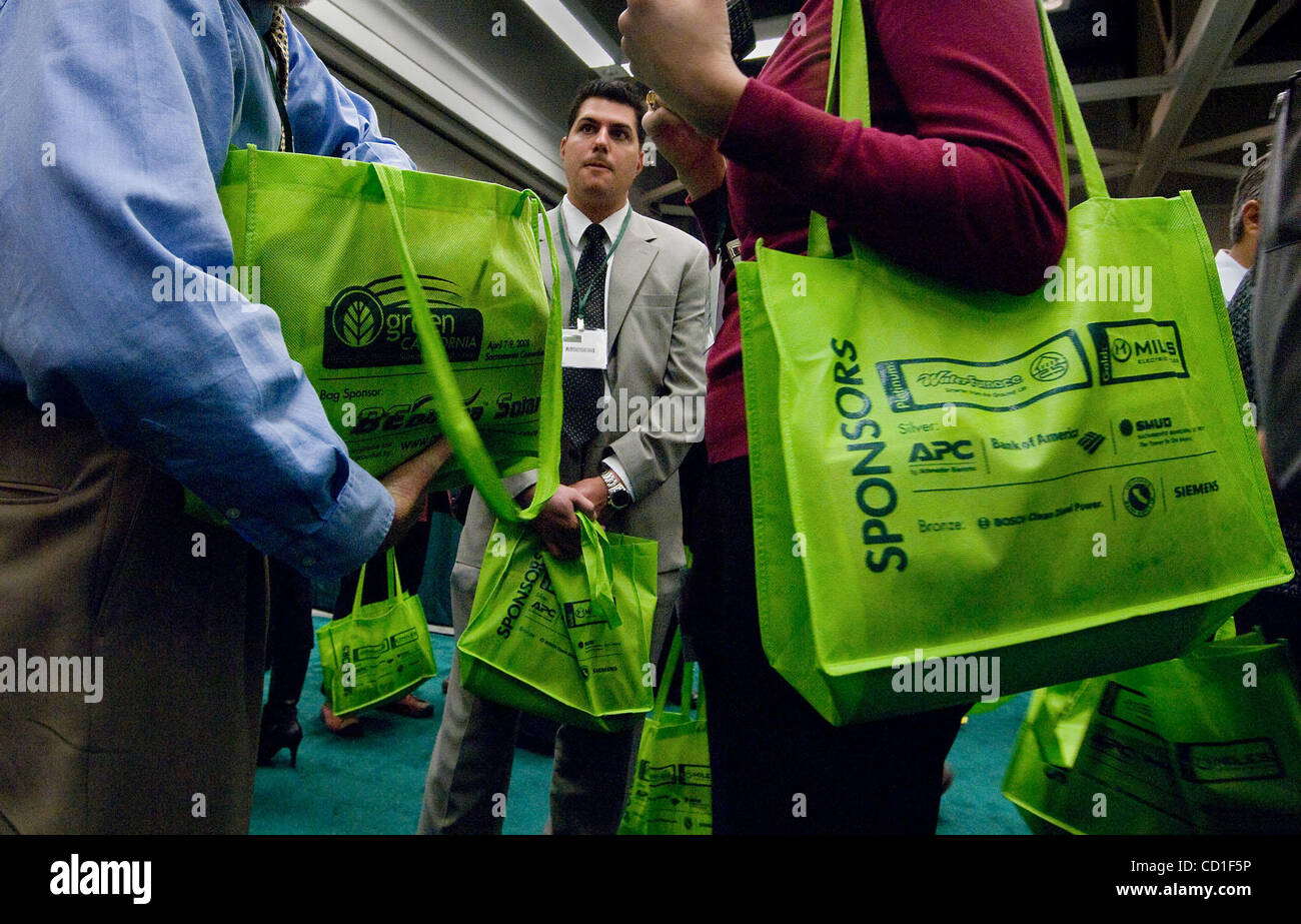 Visitors carry free green tote bags at the Sacramento Green Summit and ...