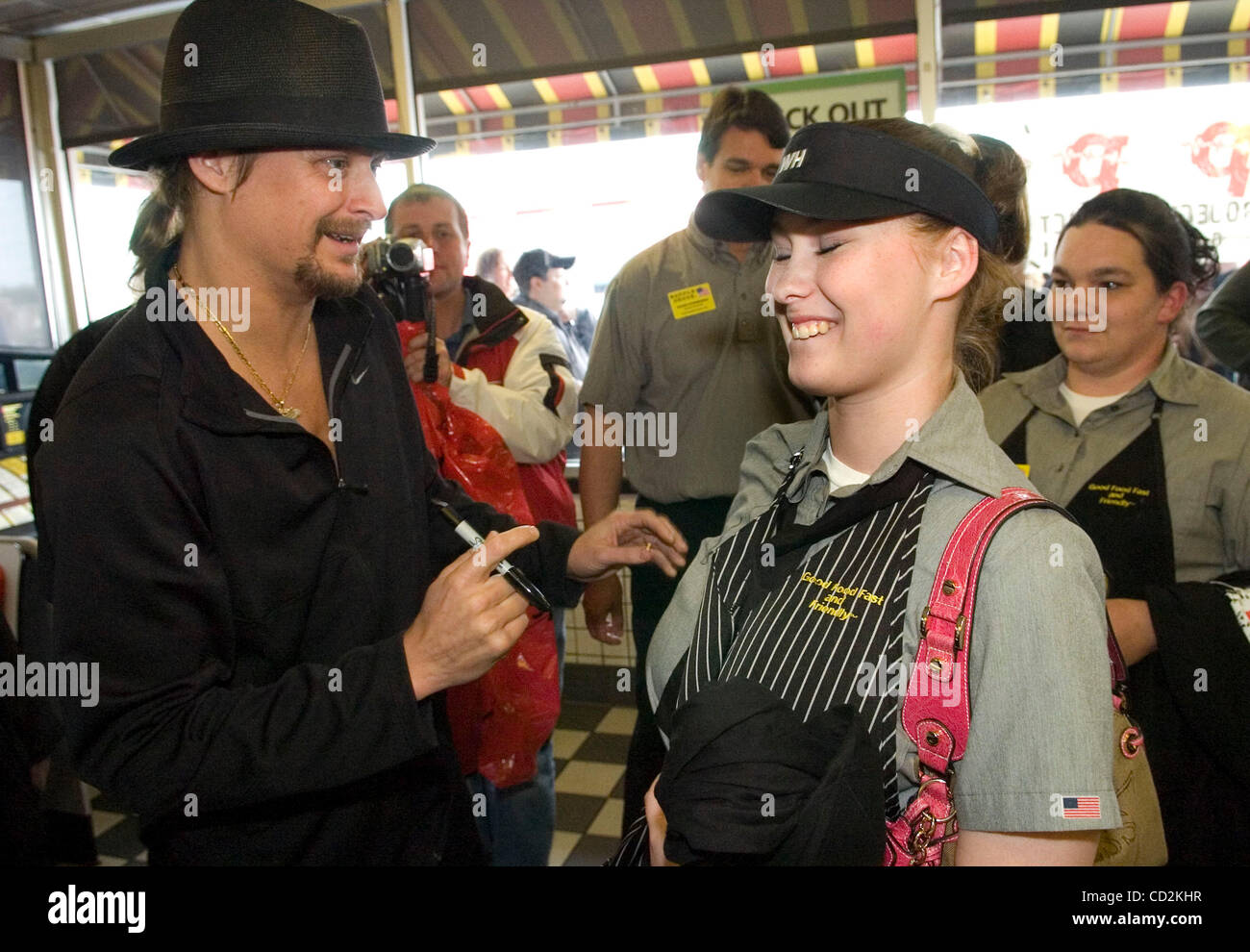 Musician singer Kid Rock (L) signs the uniform of employee Kayla Bowman ...