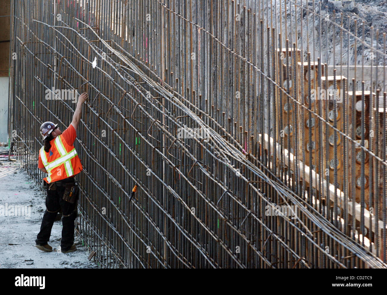 A worker adds concrete reinforcing rebar as construction continues on ...