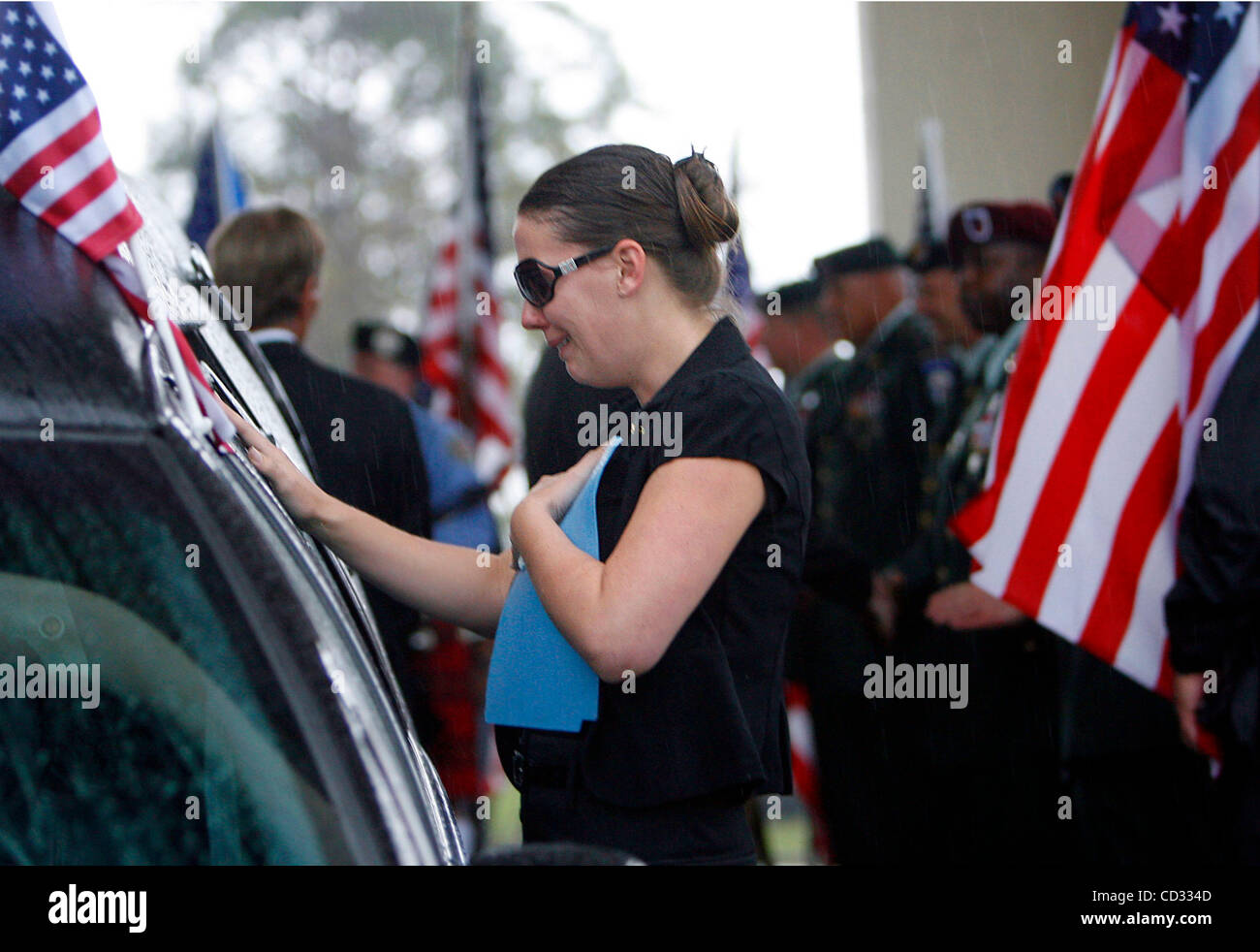 Tara Nelson takes a private moment at the hearse holding the coffin of ...
