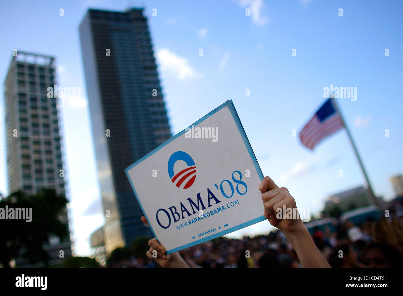 An Obama supporter waves an sign at the end of his early vote for ...