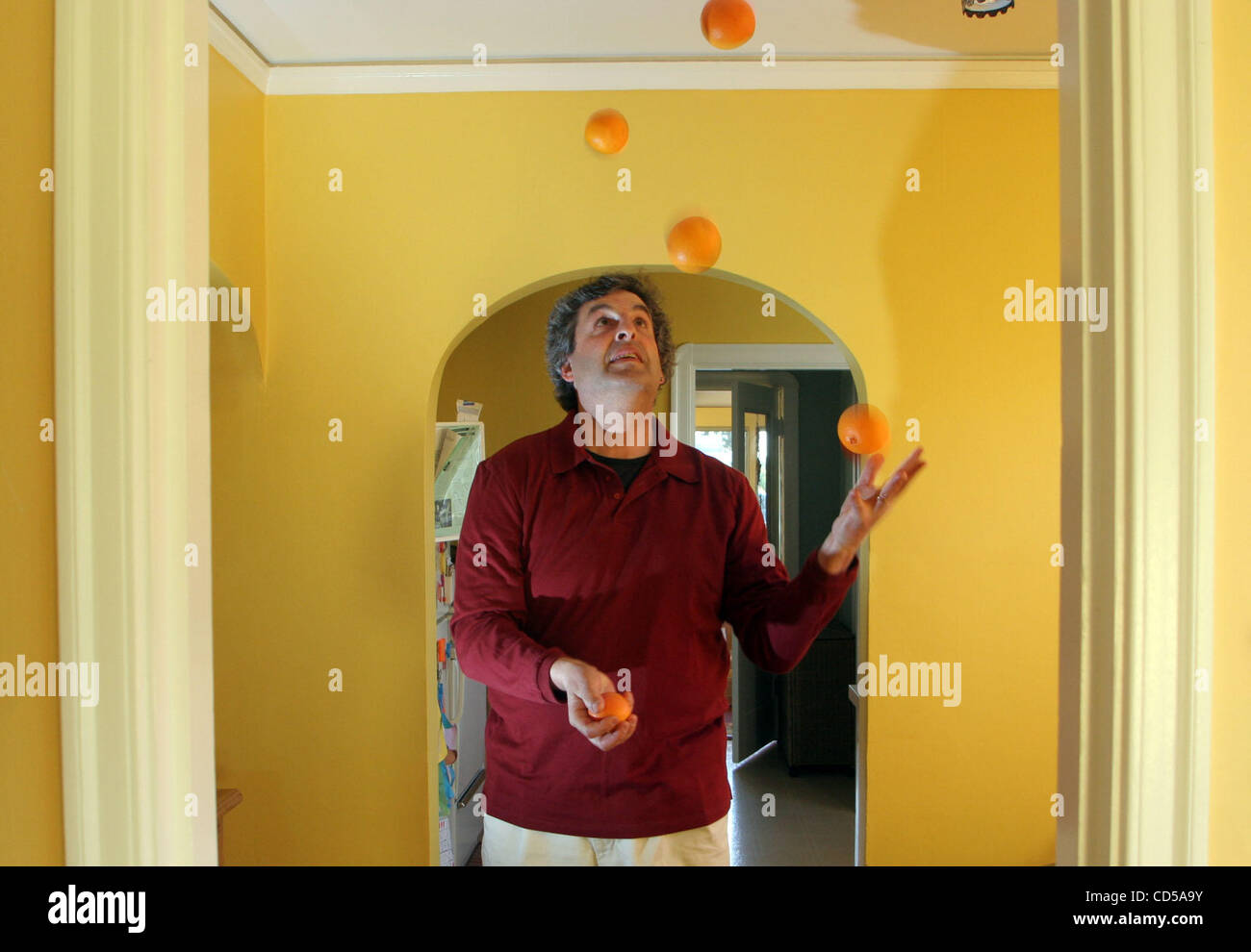 Jeff Raz, a professional clown, juggles five oranges at his home in ...