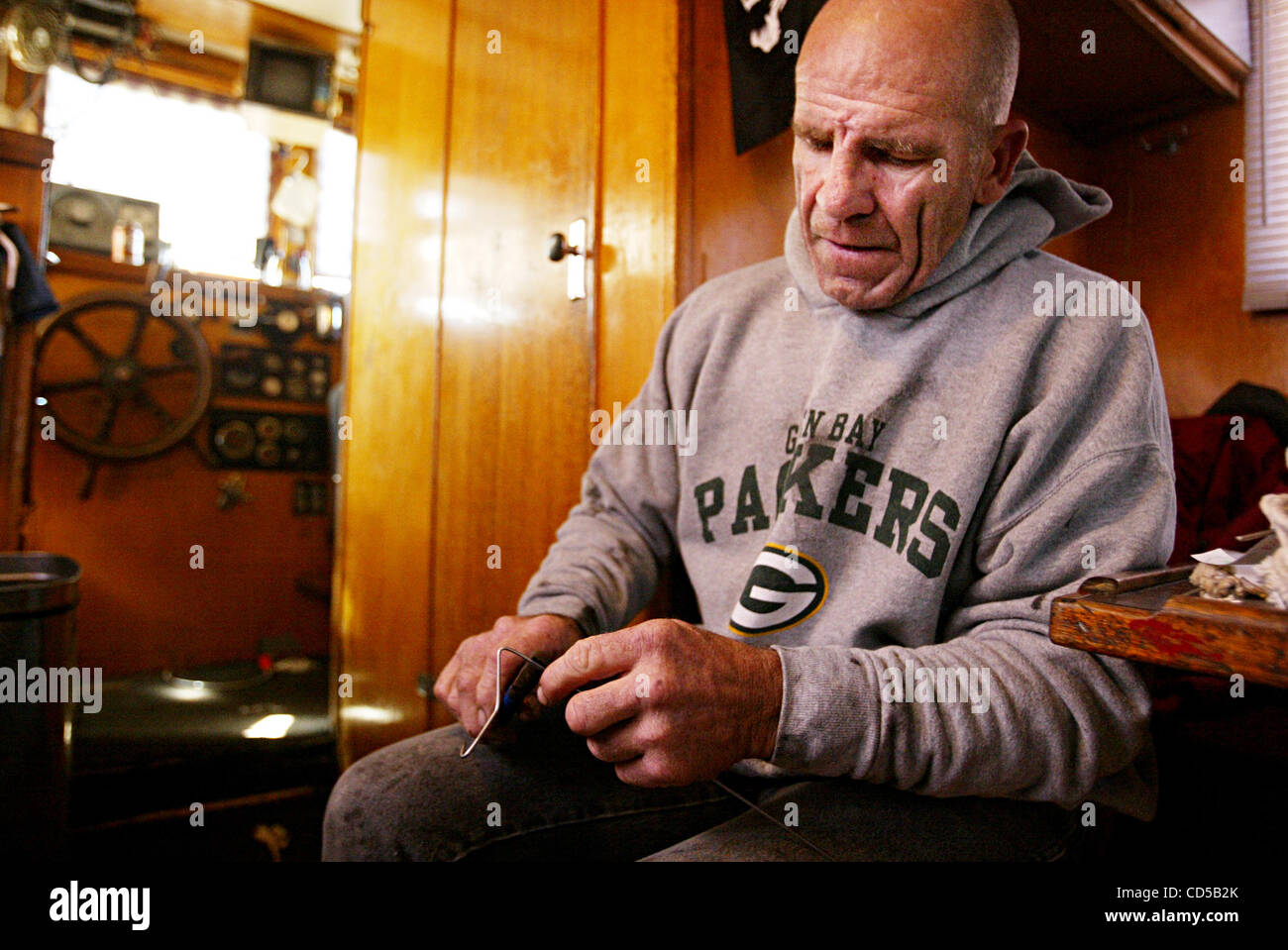 Fisherman Duncan MacLean bends a metal rod into hooks for crab traps ...