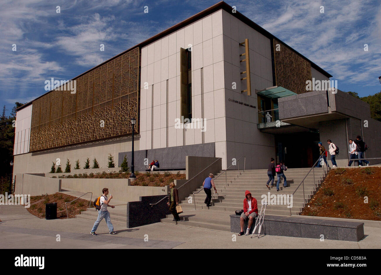 Students walk by the new library that will have a Monday through Friday ...