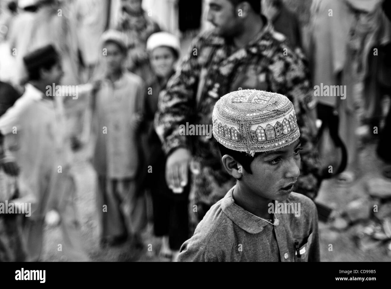 An Afghan boy listens to elders and Afghan National Army soldiers talk ...