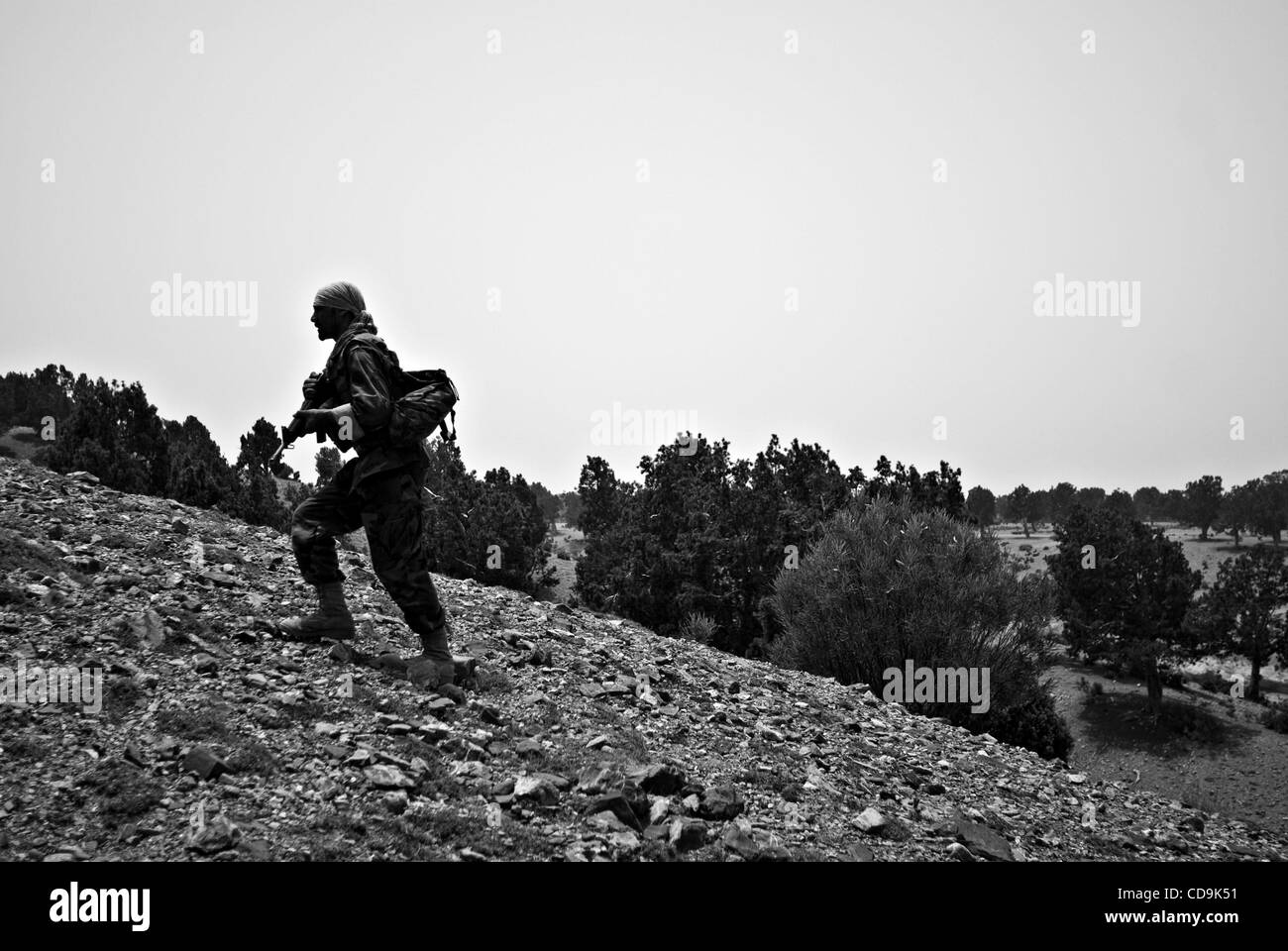 An Afghan National Army soldier climbs a hill during a foot patrol near ...