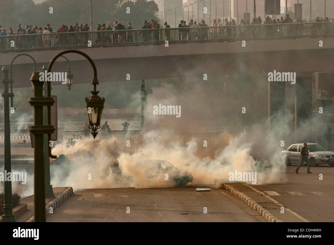 Jan 28, 2011 - Cairo, Egypt - Protesters watch from a bridge as a car ...