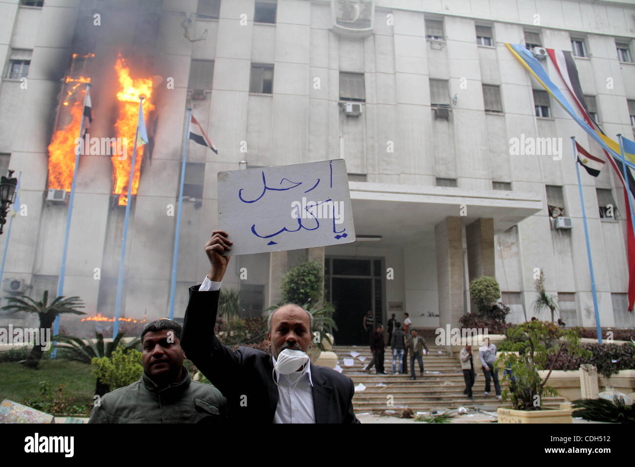 Egyptian protesters stand in front of burning building during a anti ...