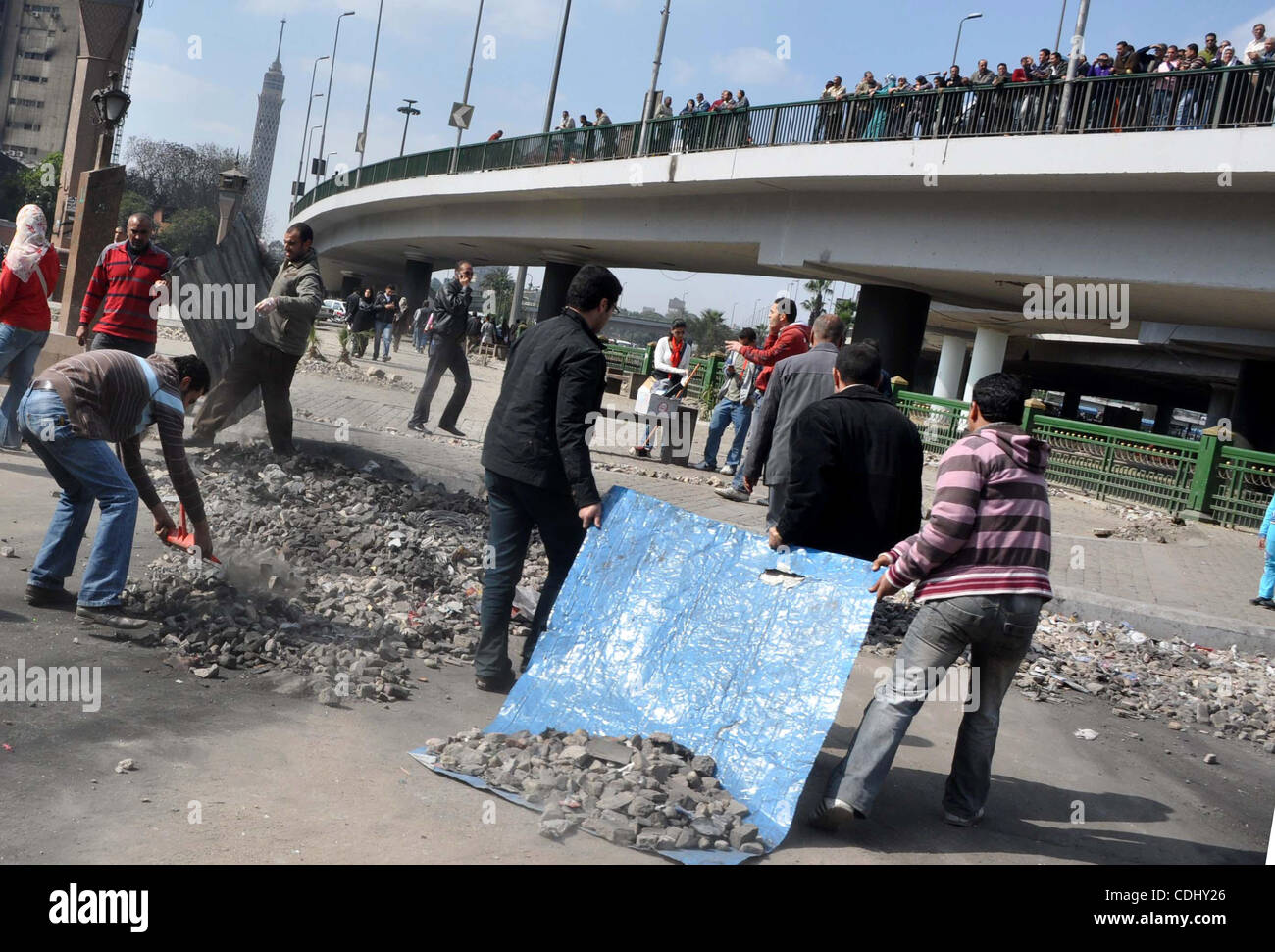 Egyptians clean up garbage and rocks from a street near Tahrir Square ...