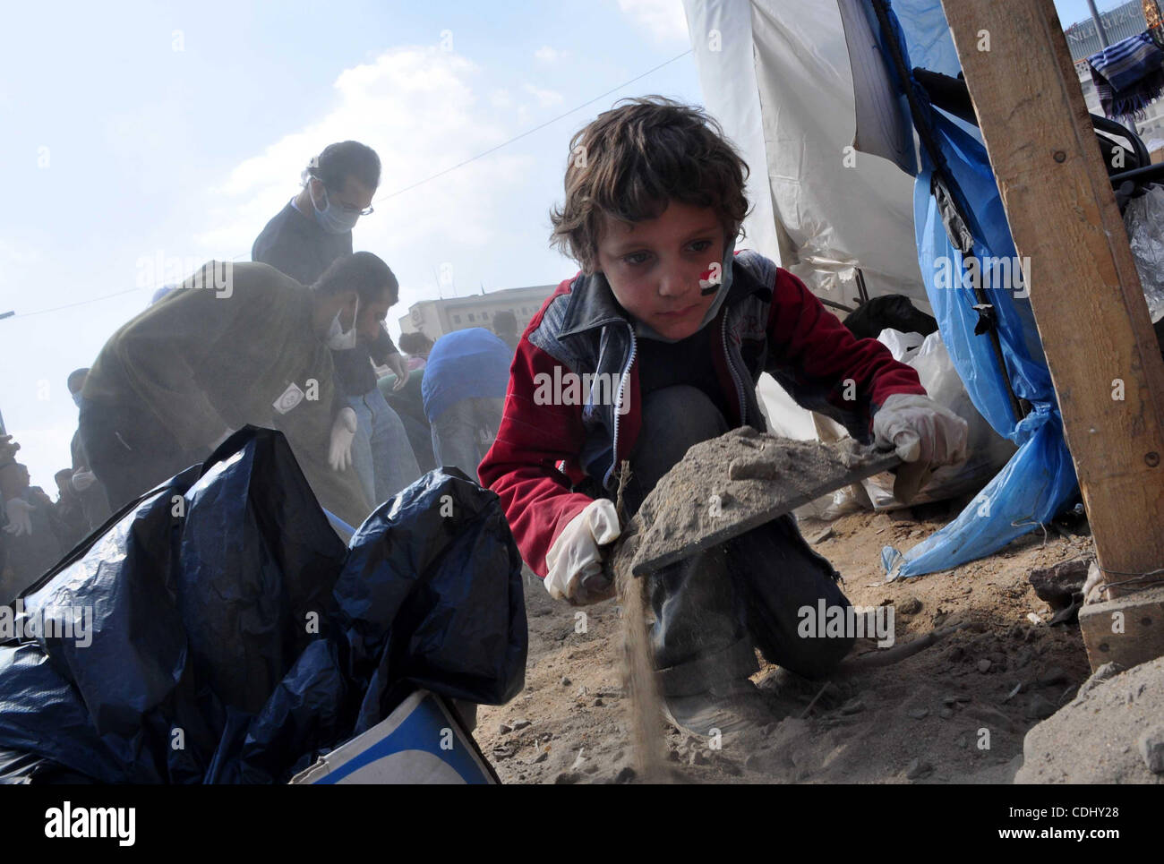 Egyptians clean up garbage and rocks from a street near Tahrir Square ...