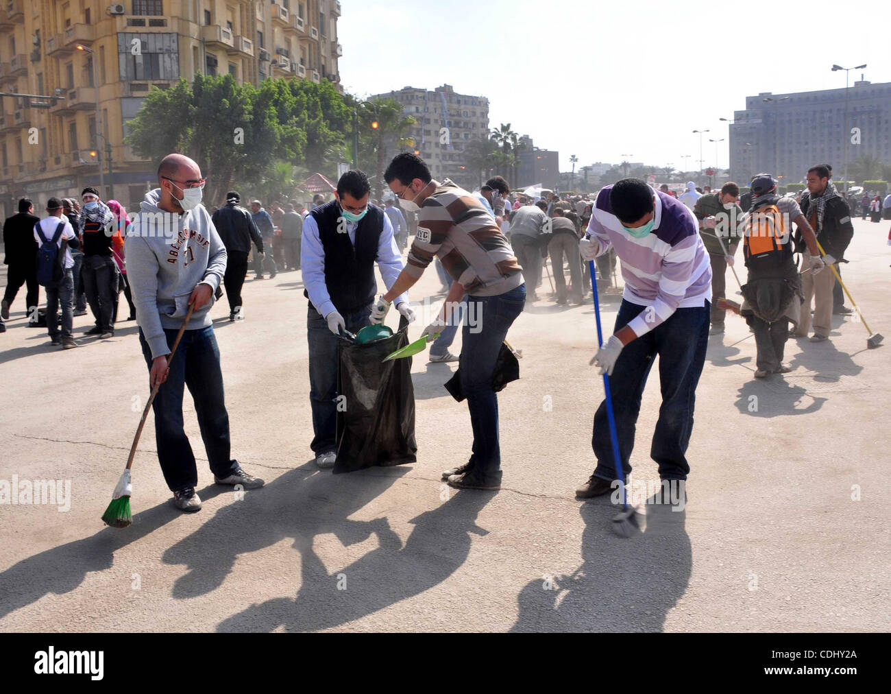 Egyptians clean up garbage and rocks from a street near Tahrir Square ...