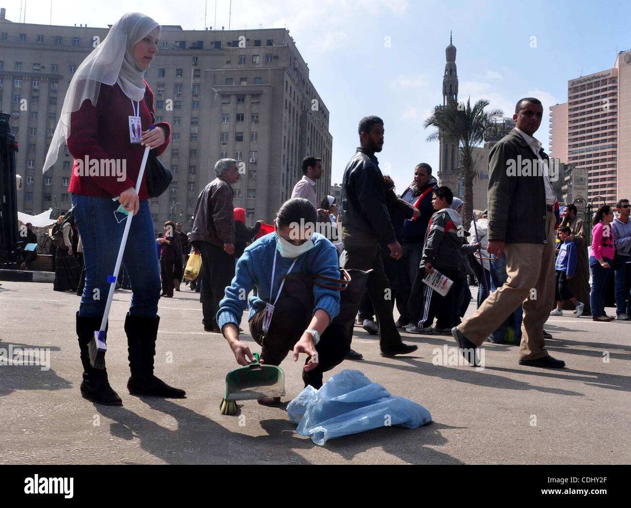 Egyptians clean up garbage and rocks from a street near Tahrir Square ...