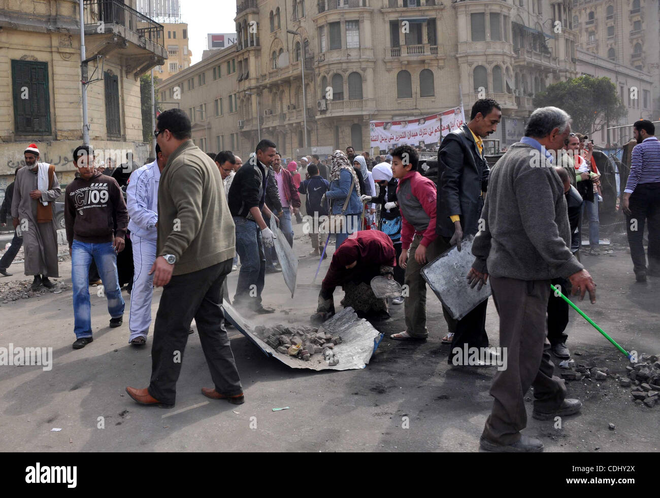 Egyptians clean up garbage and rocks from a street near Tahrir Square ...