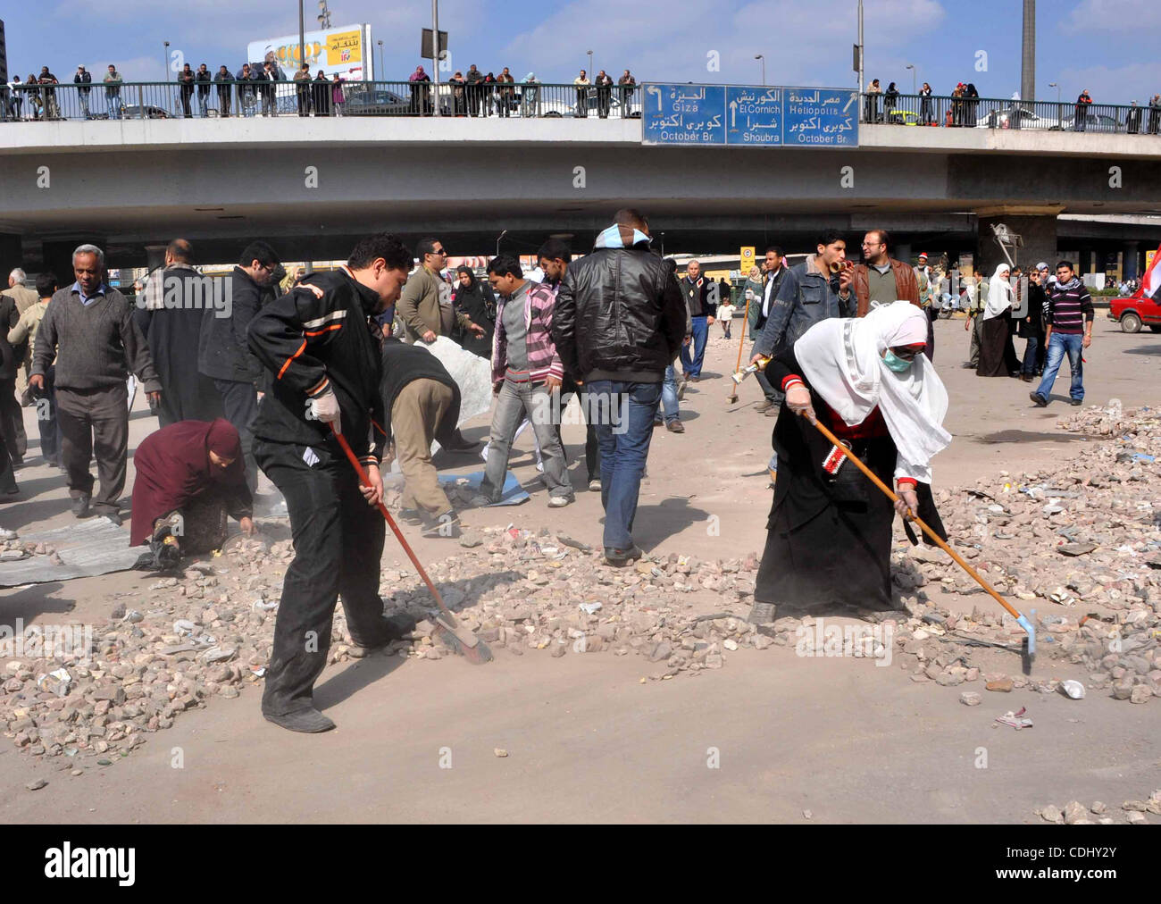 Egyptians clean up garbage and rocks from a street near Tahrir Square ...