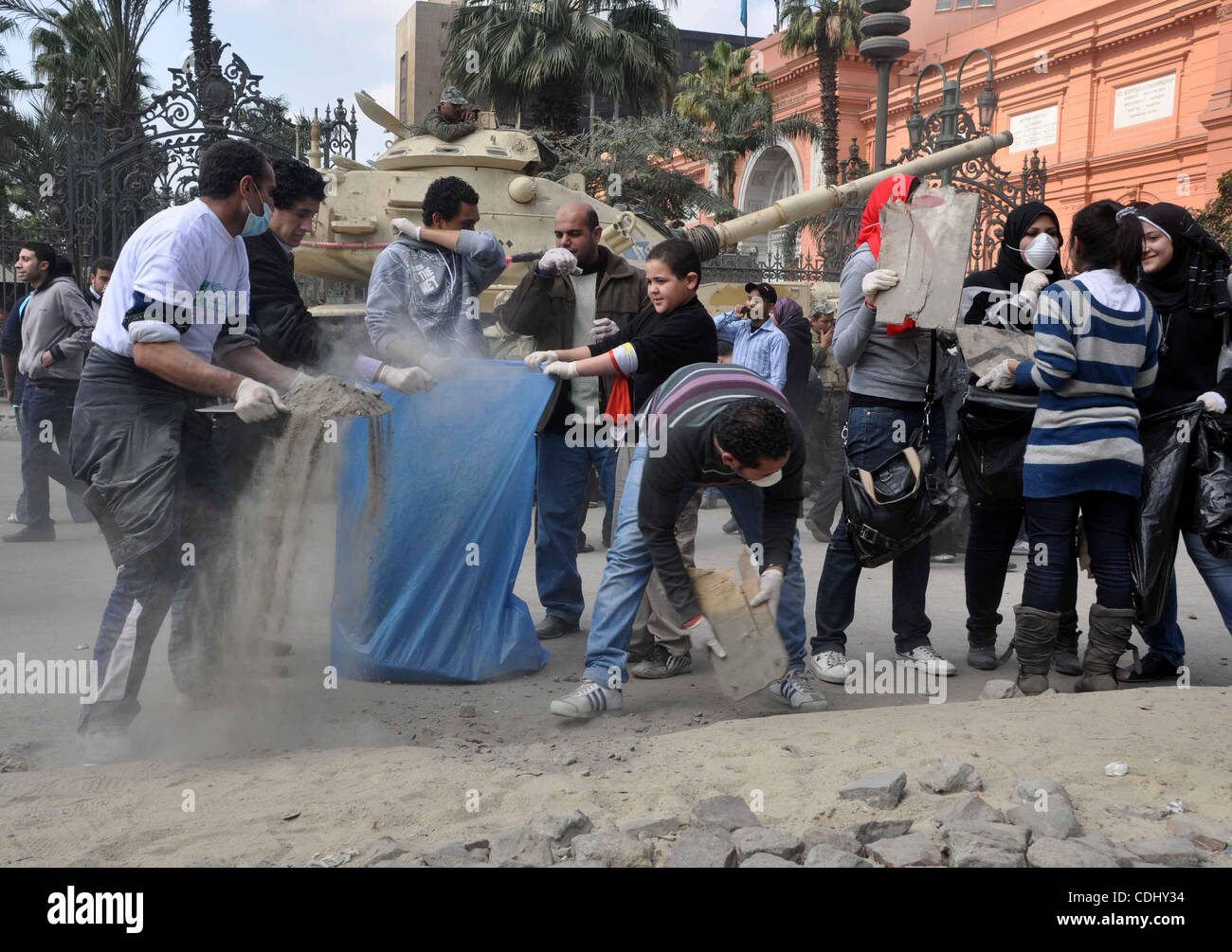 Egyptians clean up garbage and rocks from a street near Tahrir Square ...