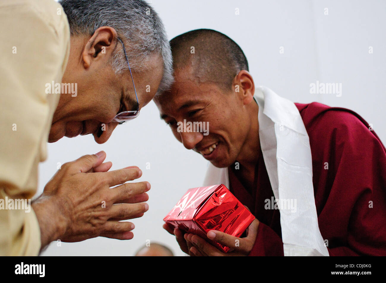 A monk receives a gift during his ordination ceremony at the Buddhist ...