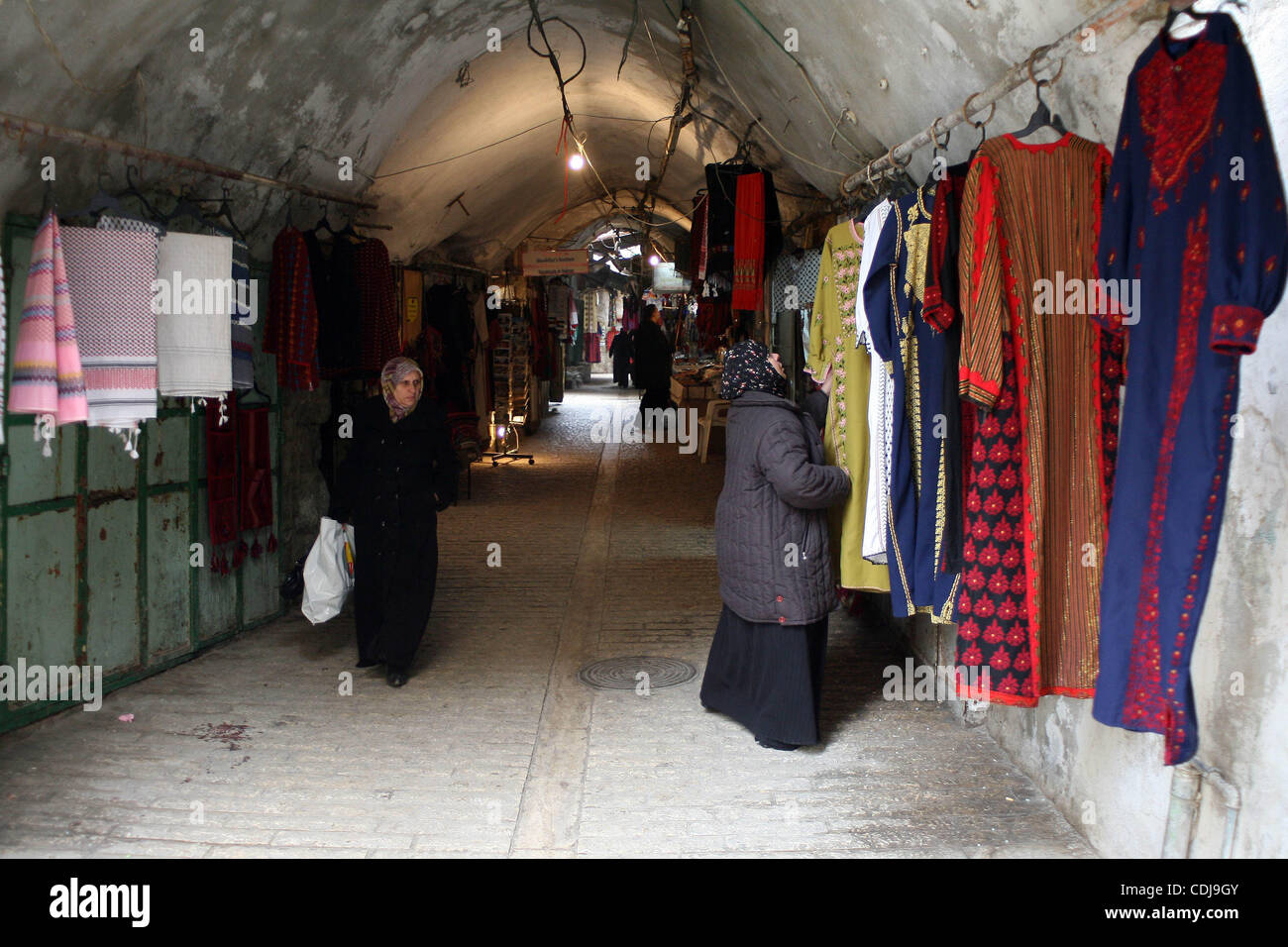 Palestinians shop in a traditional market at the old city in the West ...