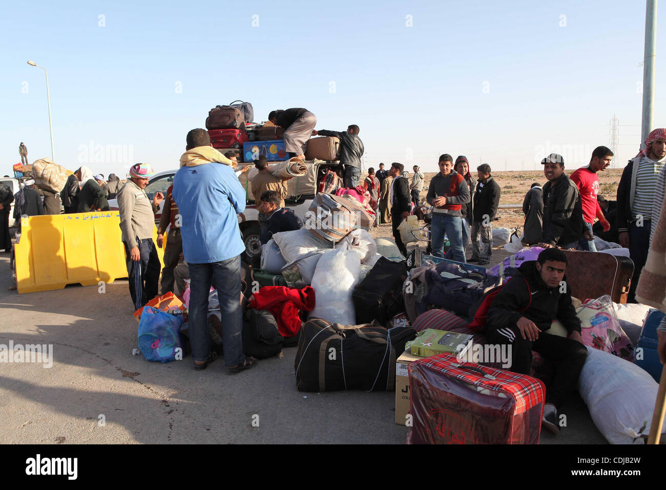 Egyptians, who have fled from Libya through the Salloum land port gate ...