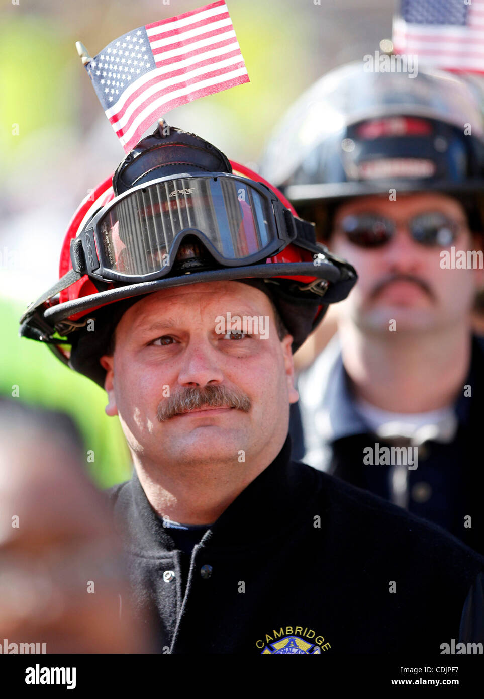Firefighters from Cambridge, Ohio, listen to speakers during a rally ...