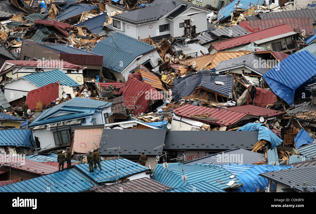 Mar. 15, 2011 - Miyako, Japan - People stand on the roofs of collapsed ...