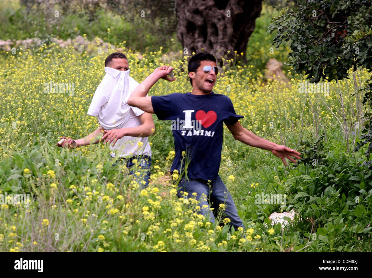 Palestinian youths hurl stones towards Israeli soldiers during a ...