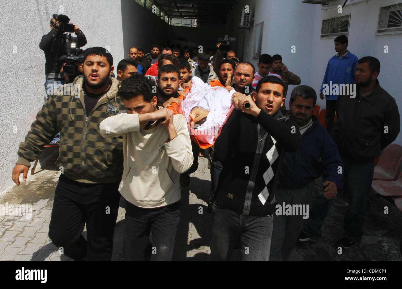 Palestinian mourners carry the body of Mohammed Shalha during his ...