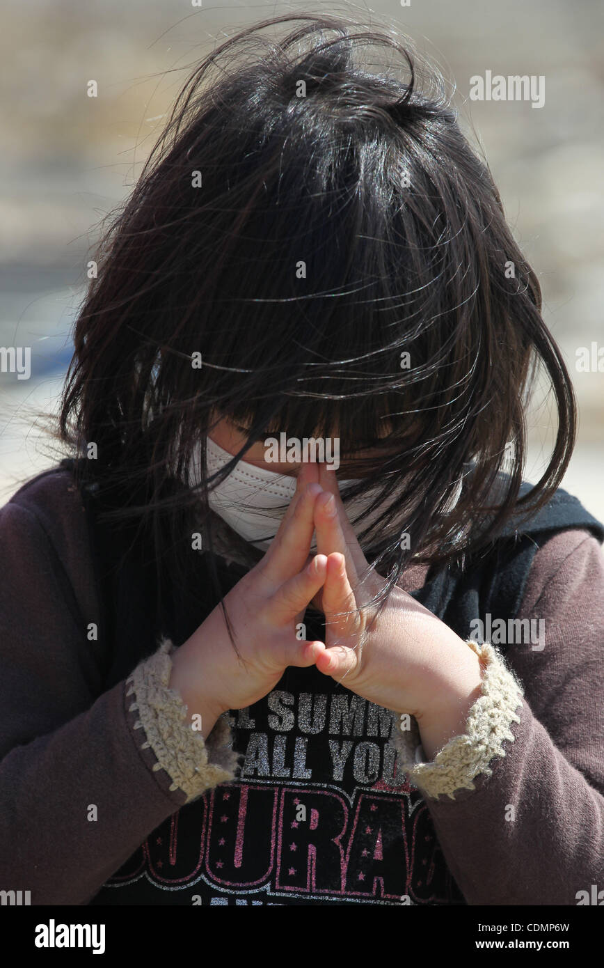 Apr. 12, 2011 - Minamisoma, Japan - A young girl prays for victims ...
