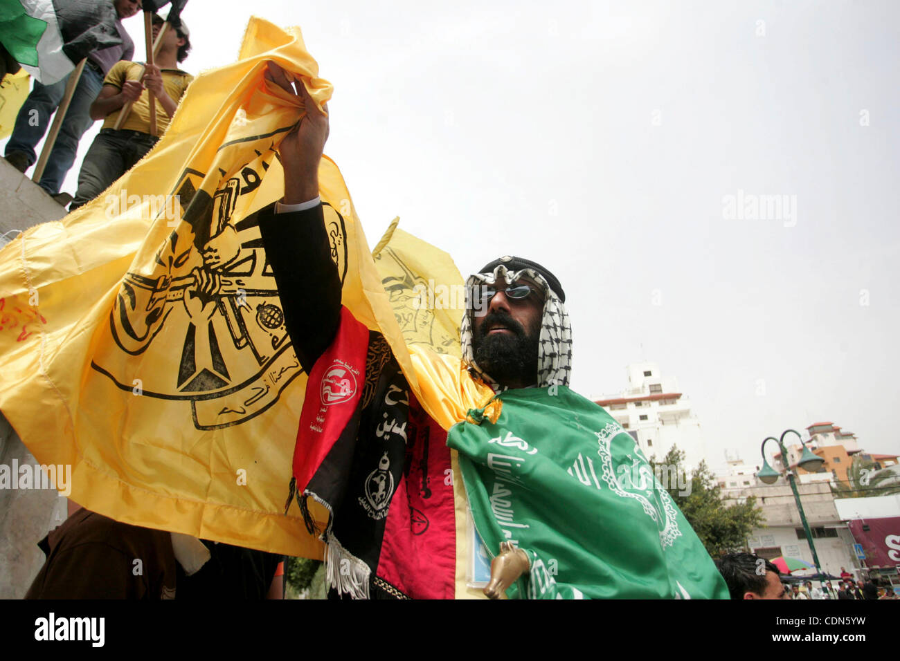 Palestinians wave with Hamas movement and Fatah party flags during a ...