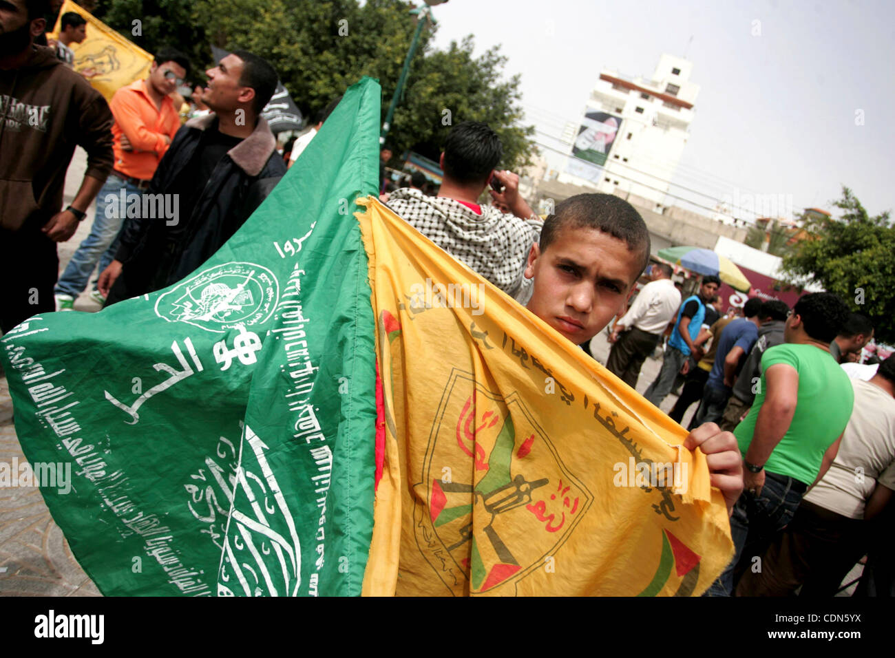 Palestinians wave with Hamas movement and Fatah party flags during a ...