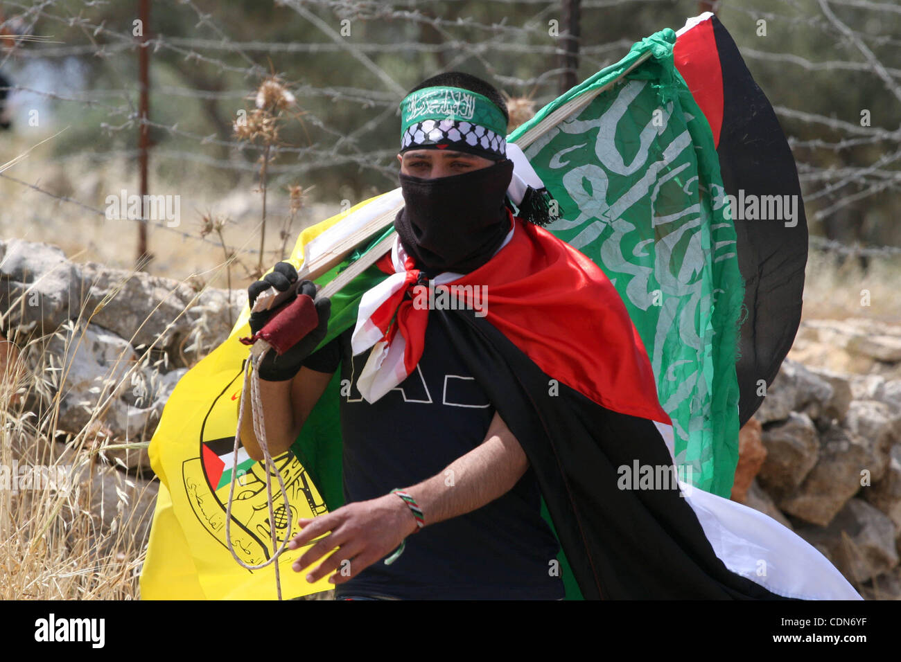 A Palestinian protestor carries the Hamas and Fatah flags during a ...