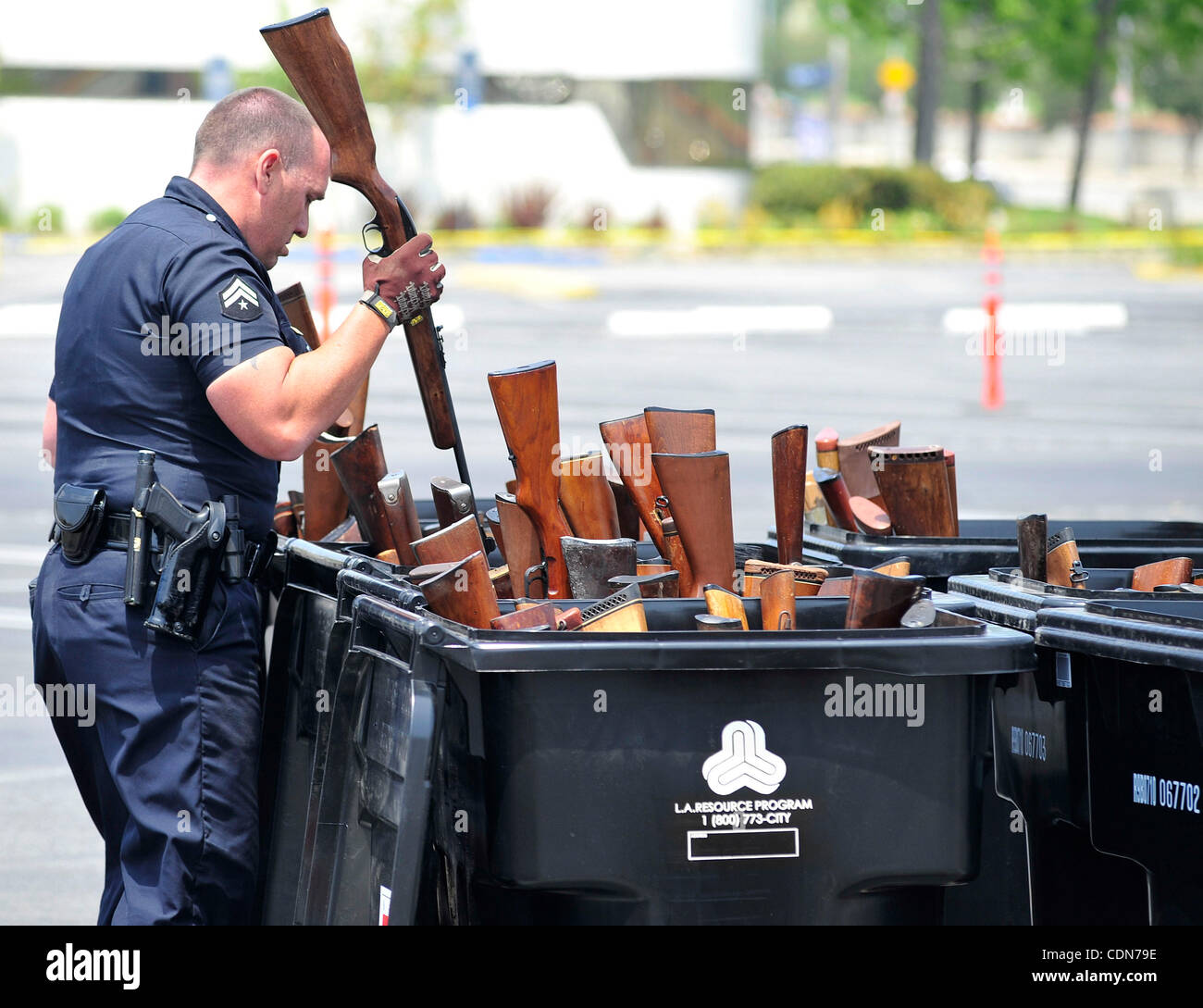 A Los Angeles Police Officer places a rifle into a collection bin after ...