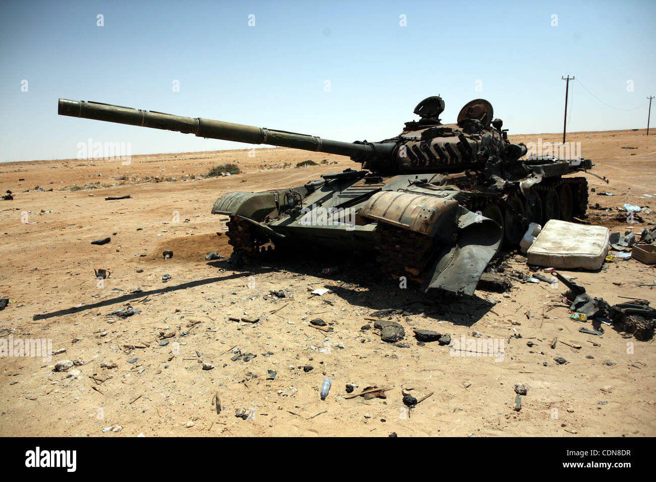 A burnt tank is seen as Libyan rebel fighters head towards the front ...
