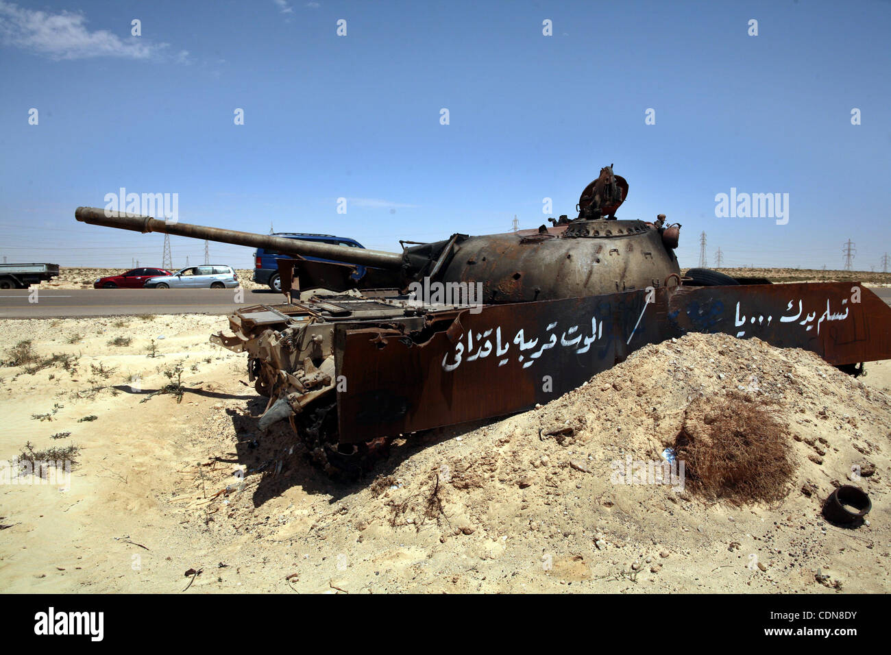 A burnt tank is seen as Libyan rebel fighters head towards the front ...