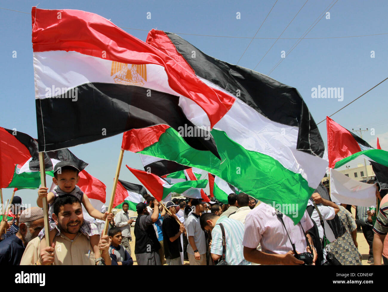 Palestinians wave with their national flag and Egyptian flag at Rafah ...