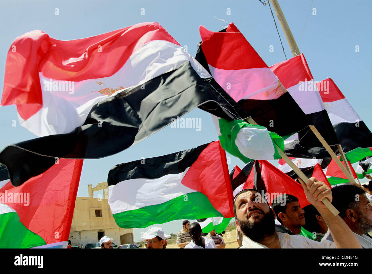 Palestinians wave with their national flag and Egyptian flag at Rafah ...