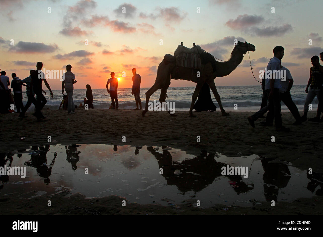 Palestinians walk along the beach in Gaza City on June 24, 2011. Photo ...