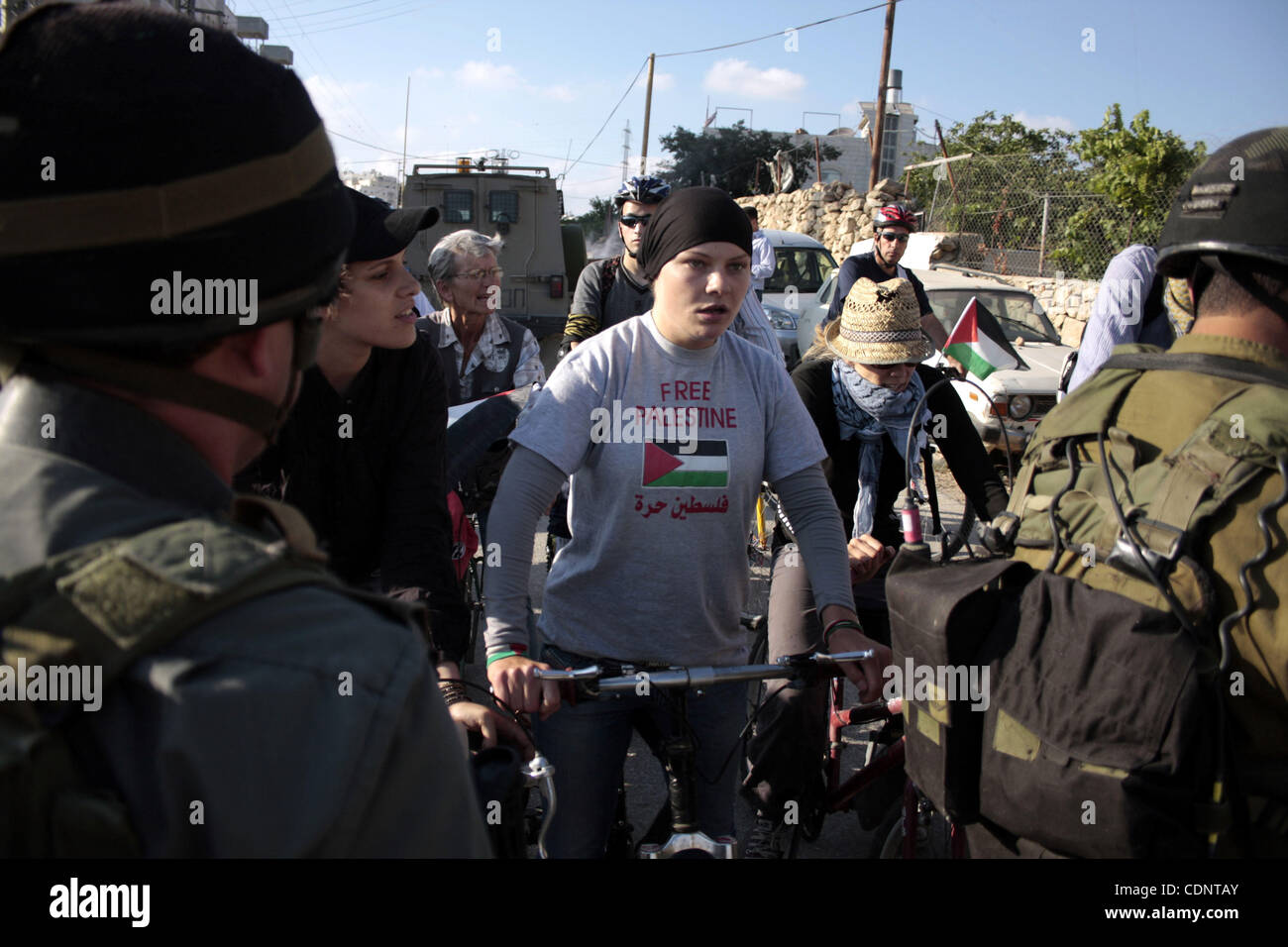 Palestinian and foreign bikers wait behind a cordon of Israeli security ...