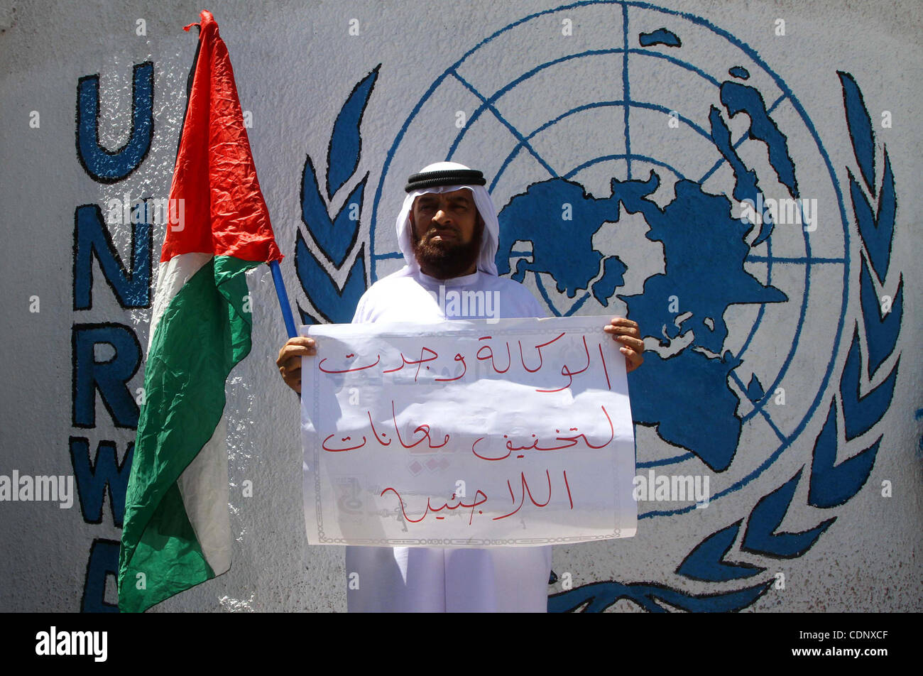 A Palestinian man holds the national flag during a protest in front of ...